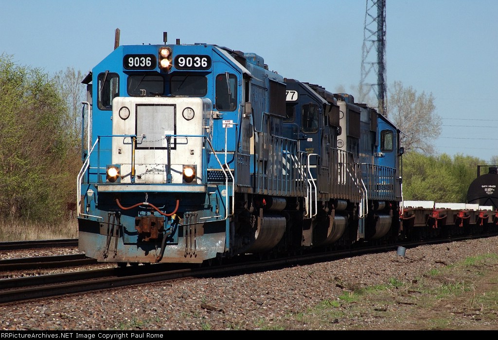 EMDX 9036, Oakway Lease unit leads sister Oakway and Helm Lease unit eastbound at Holiday on the ...